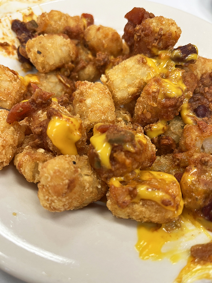 Cheese-covered tater tots that make you question why anyone would ever choose a side salad when this golden, crispy alternative exists.