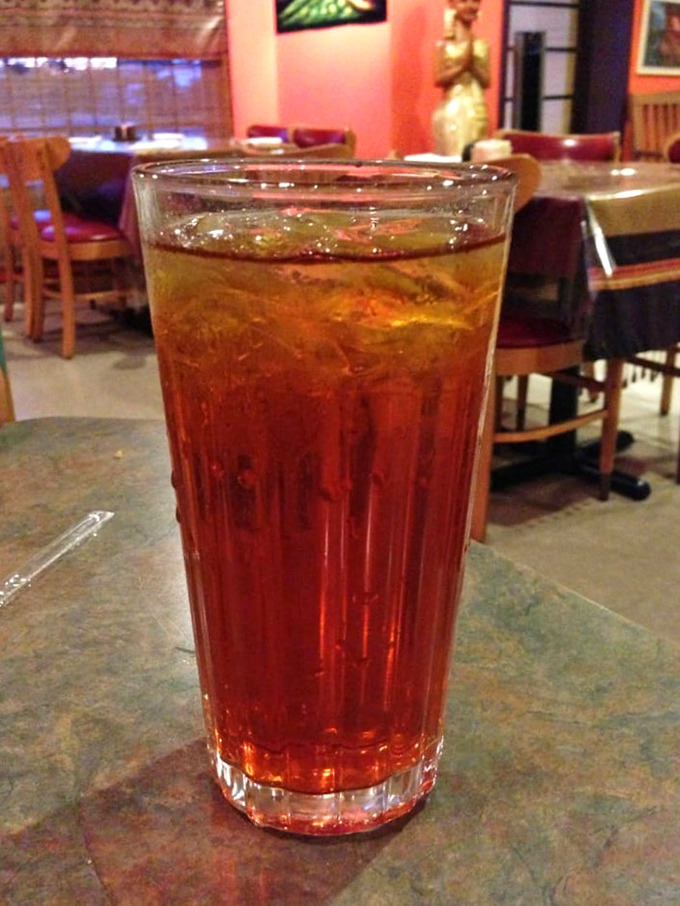 The Thai iced tea glows like a sunset in a glass, promising sweet relief after your spicy adventure through the menu.