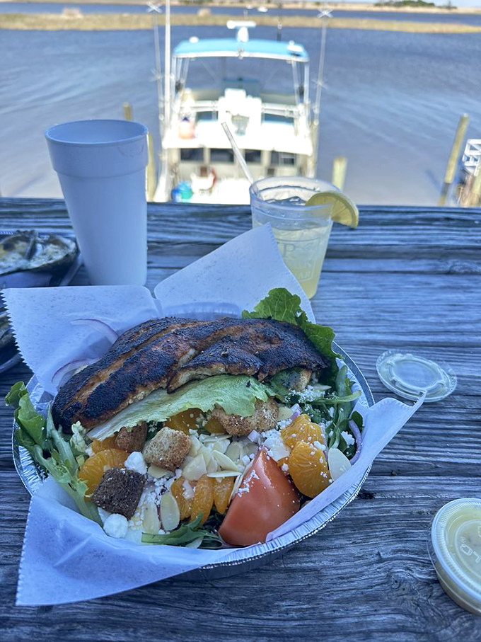 A blackened fish salad with vibrant oranges and greens, served with a side of Florida sunshine and boat-watching opportunities.