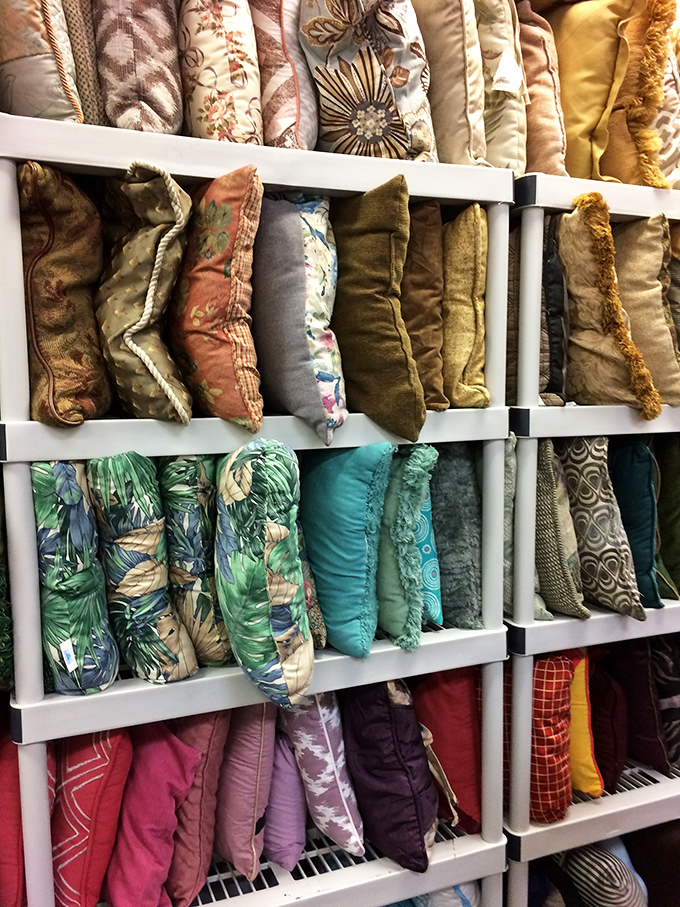 Throw pillows arranged like a textile color story. The tropical prints on the middle shelf are practically screaming "Florida living room makeover" at bargain prices.