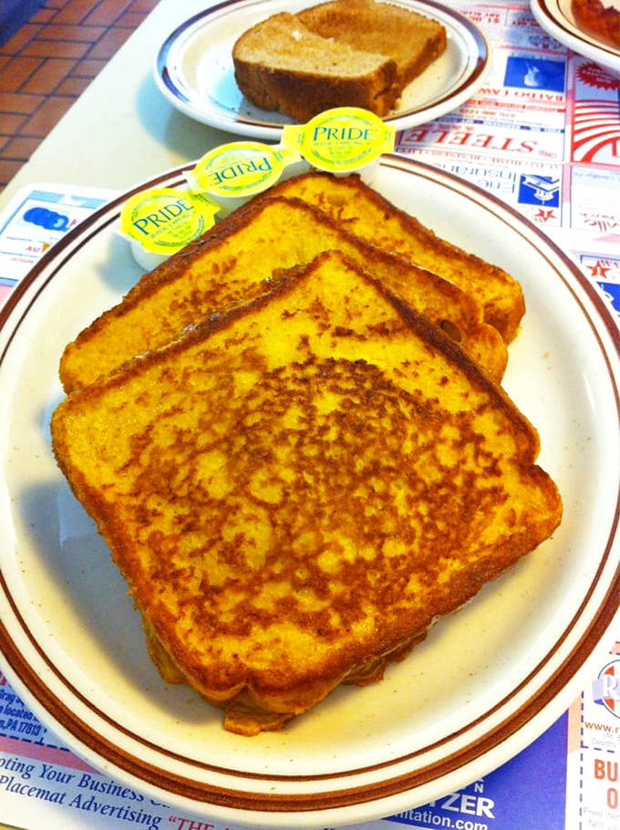 French toast that makes you question why anyone bothers with fancy brunch. Three pats of butter standing by like little yellow lifeguards.