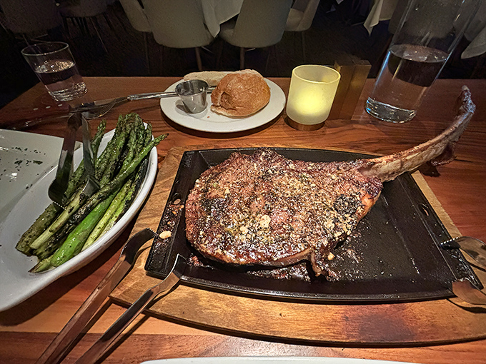 This tomahawk ribeye isn't just a steak&mdash;it's performance art with protein. Primal satisfaction served on a plate with asparagus for moral support.