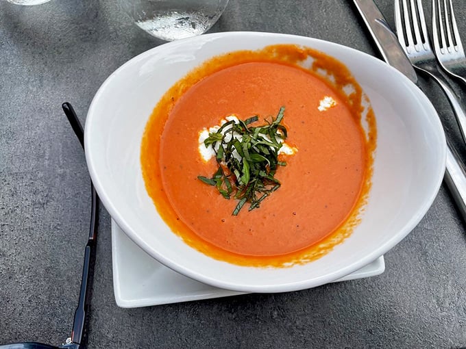 This tomato bisque isn't just soup&mdash;it's a warm embrace in a bowl. The basil garnish isn't merely decorative; it's the aromatic exclamation point on liquid perfection.