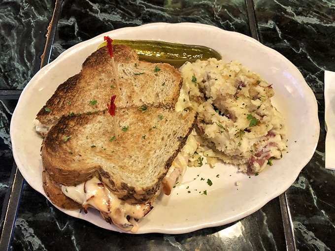 A sandwich that demands to be photographed before eaten &ndash; melty cheese cascading over toasted bread with that pickle spear standing guard.