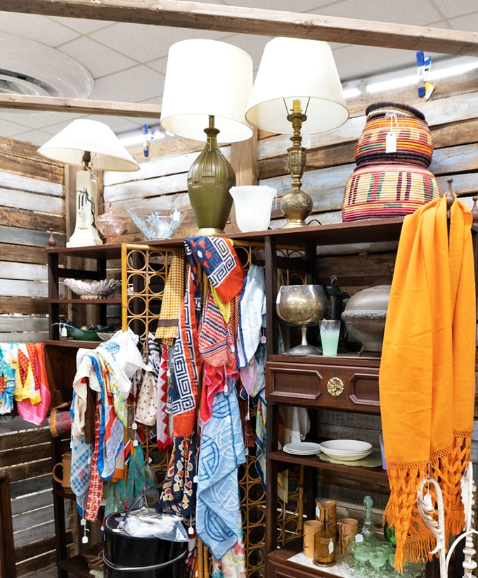 Vintage scarves flutter like colorful flags among mid-century lamps and glassware, creating a bohemian corner that would make your coolest aunt jealous.