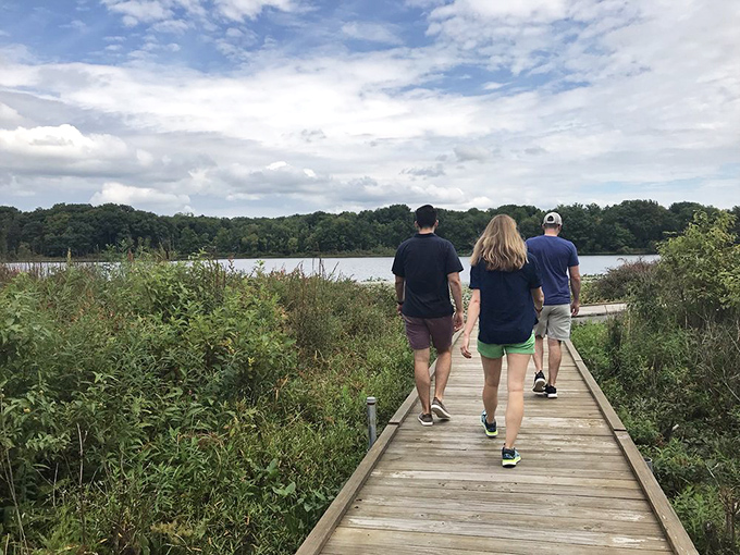 Three explorers following the wooden path toward discovery &ndash; sometimes the best conversations happen while walking side by side.