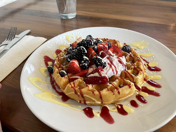 Berry-crowned waffle royalty! The perfect balance of crisp exterior and fluffy interior, drizzled with sauces that would make Jackson Pollock jealous. 