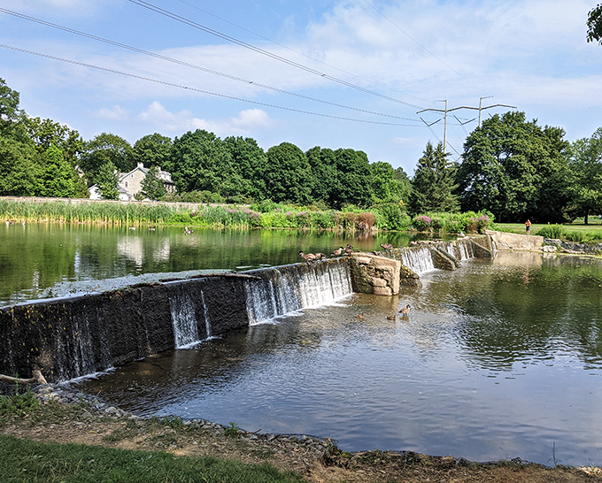 Jordan Creek's gentle cascade creates nature's soundtrack beneath the bridge, a peaceful counterpoint to the solid stonework of the historic dam.