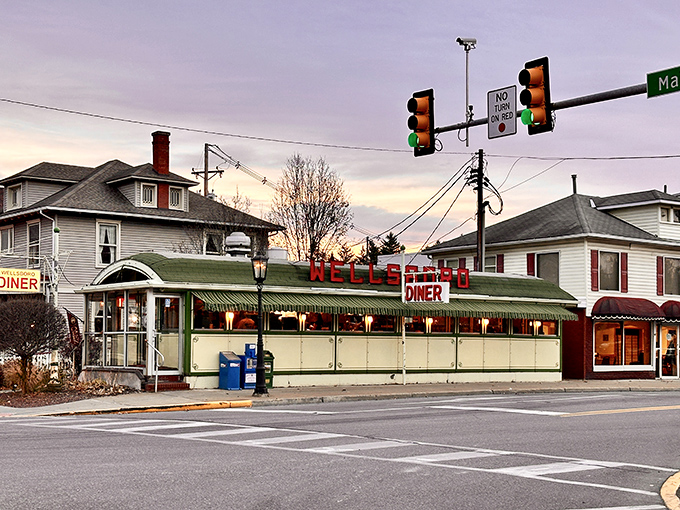The iconic Wellsboro Diner gleams in twilight, its vintage dining car design a beacon to hungry travelers seeking authentic American comfort food without pretense.