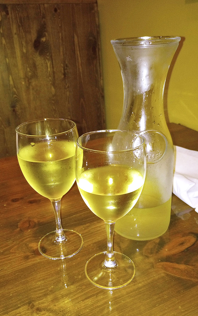 A carafe of house white wine catches the light like liquid sunshine&mdash;the perfect companion for Mediterranean flavors and leisurely conversation.
