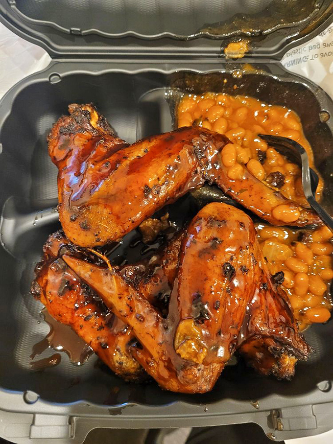 BBQ wings and baked beans in their natural habitat &ndash; a takeout container that won't make it home without at least one "just a taste" pit stop.