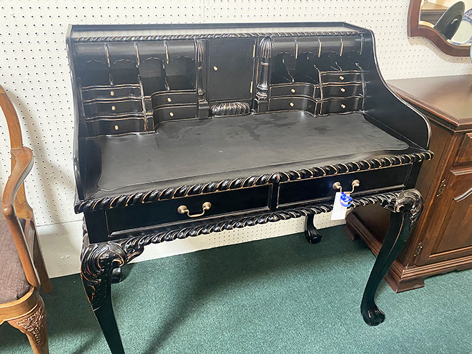 This stately black desk with its intricate detailing once witnessed the penning of letters, not the tapping of keyboards.