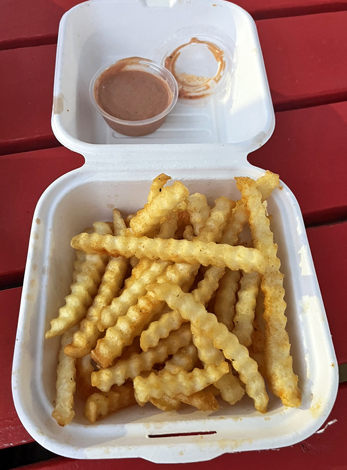 Crinkle-cut fries with that golden hue of potato perfection, accompanied by a dipping sauce that's begging for a french fry plunge.