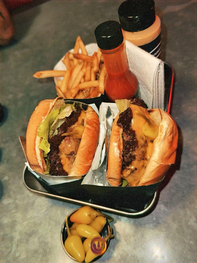 The kind of cheeseburgers that make vegetarians question their life choices. Served in metal trays because paper couldn't handle this level of deliciousness.