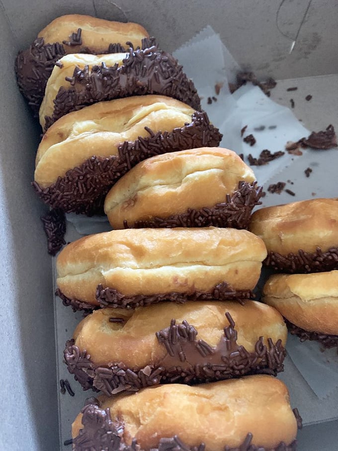 Chocolate-dipped long johns lined up like delicious soldiers, ready to sacrifice themselves for your morning happiness.