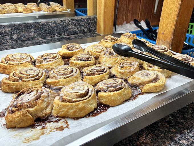 Cinnamon rolls lined up like sweet, spiral-shaped soldiers, their glazed armor glistening under the buffet lights, awaiting your surrender.