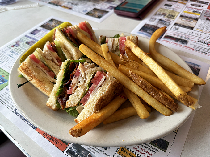 The club sandwich – architecture you can eat. Those perfectly stacked layers deserve their own blueprint, with fries standing guard like golden sentinels.