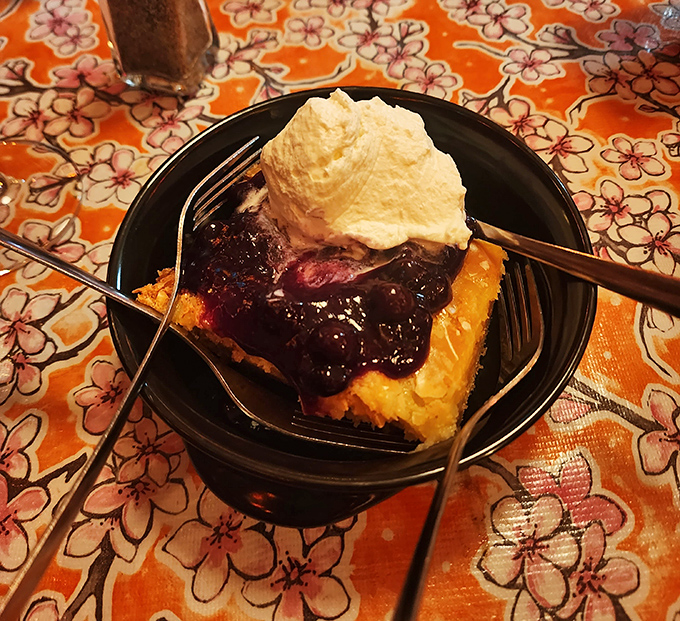 Dessert that makes you want to write poetry: warm fruit cobbler topped with a cloud of whipped cream that melts into sweet, jammy perfection.