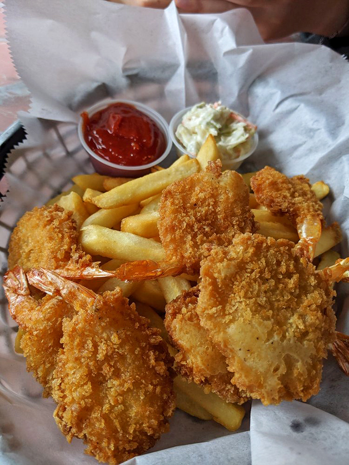 Jumbo shrimp with a golden-brown crust served alongside crispy fries and homemade coleslaw&mdash;seafood comfort that makes you forget you're miles from any ocean.