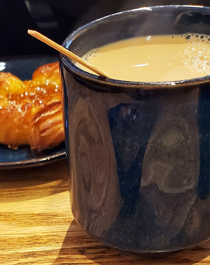A proper ceramic mug of coffee alongside what appears to be a croissant&mdash;the breakfast combination that has launched a million productive mornings.