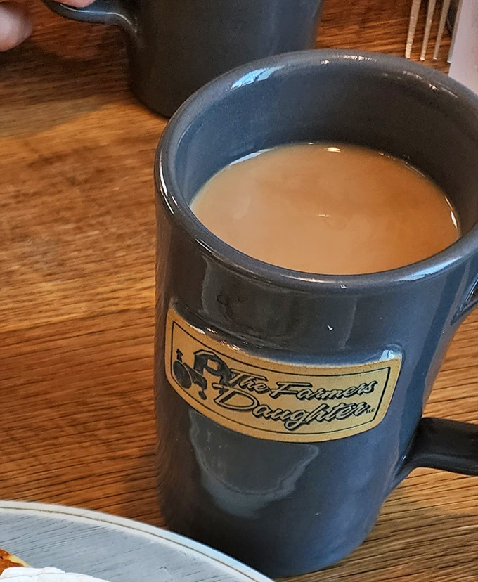 The official morning negotiator: a sturdy blue mug of coffee bearing the restaurant's logo, ready to mediate between you and Monday.