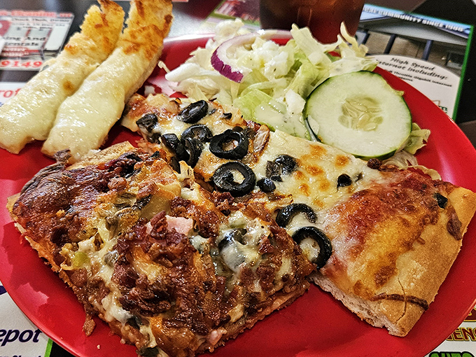 The holy trinity of pizza dining: perfectly topped slices, crisp salad, and cheese bread that makes you question why you'd eat bread any other way.