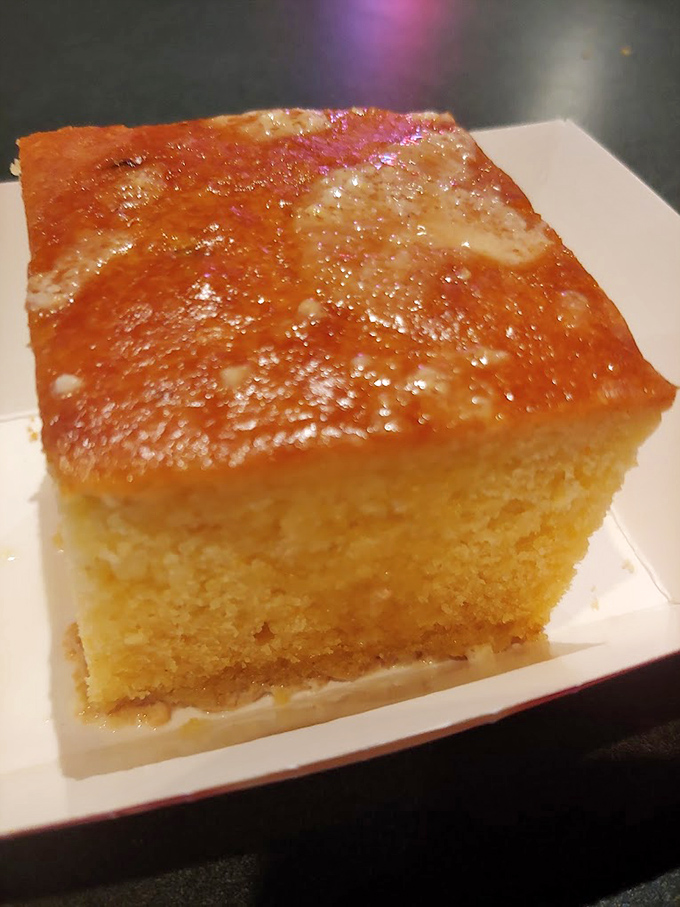 Cornbread so moist it should have its own fan club, glistening with honey butter that melts into every perfect square inch.