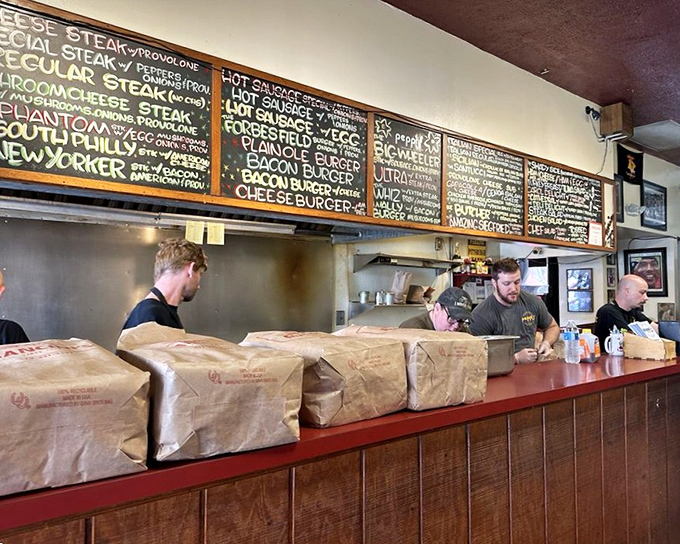 Behind the counter where sandwich magic happens. These aren't just cooks; they're artists whose canvas happens to be bread and meat.