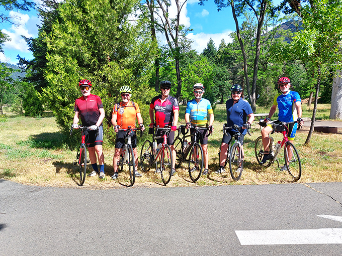 The spandex brigade takes a breather. These cyclists have discovered the perfect pit stop where the views justify every uphill pedal stroke.