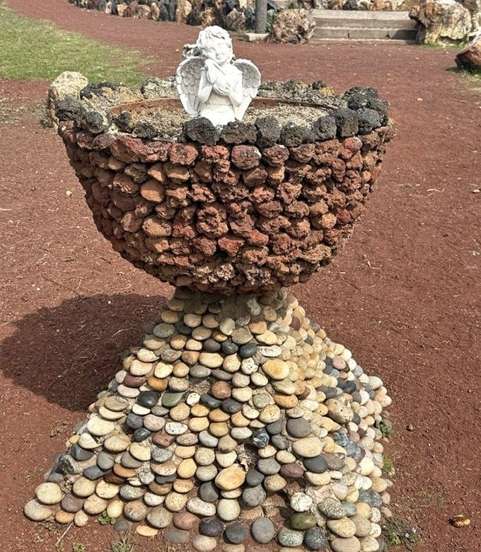 Not your average garden planter&mdash;this volcanic rock chalice topped with a cherub proves even angels appreciate good stonework.