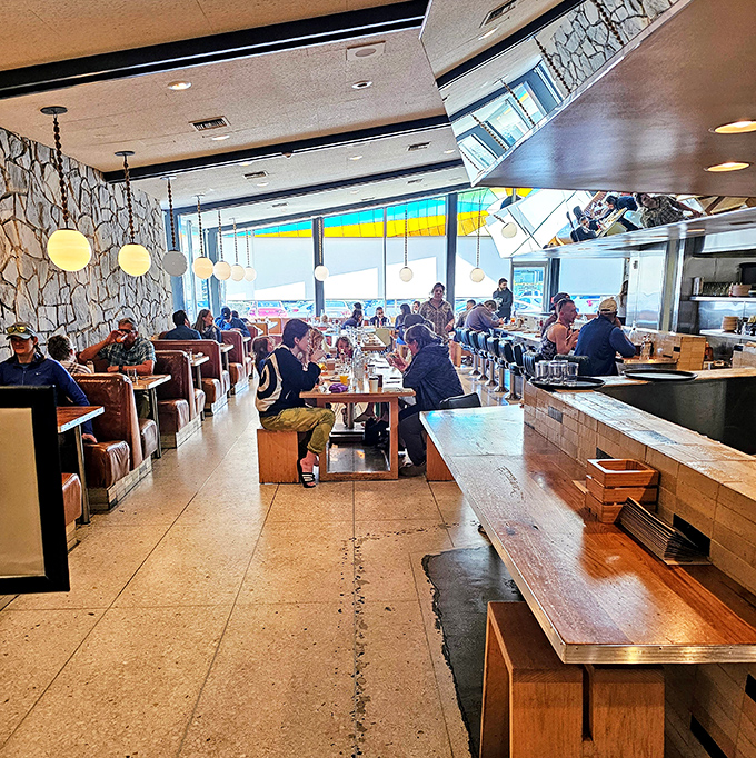 The dining room buzzes with the energy of satisfied customers, all participants in the timeless ritual of breaking bread beneath stone walls.