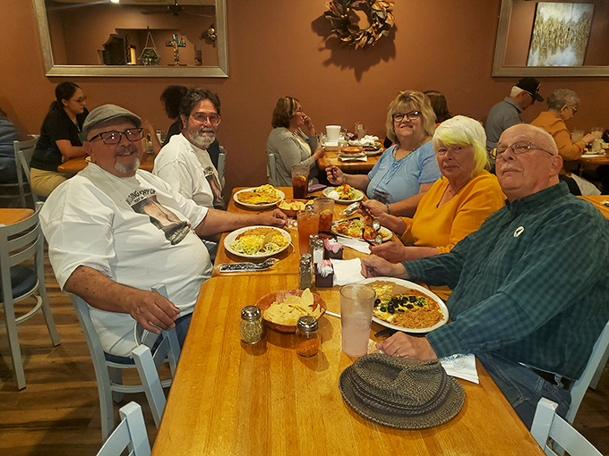 A gathering of happy diners proving that good food creates community. Those smiles aren't just from the company&mdash;they're from knowing what's about to hit their taste buds.