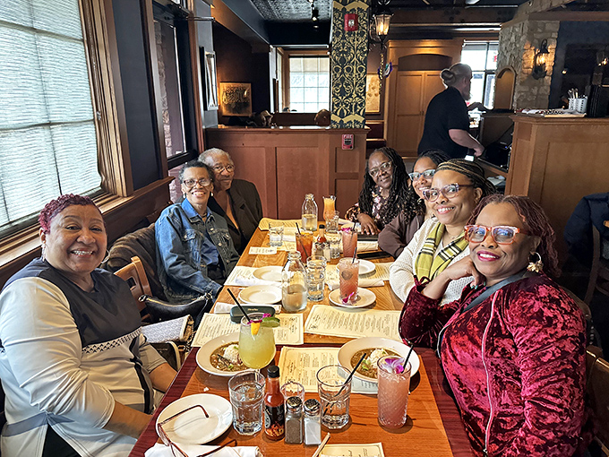 Happy diners gathered around a table of Cajun delights&mdash;proof that good food creates better conversation.