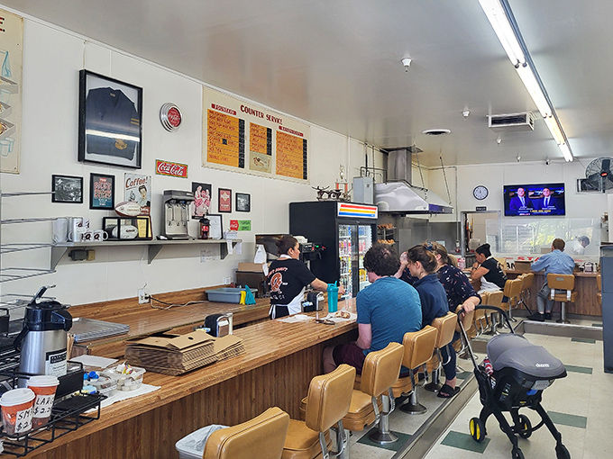 Morning philosophers gather at the counter, where coffee refills flow freely and life's problems seem smaller when viewed through a donut lens.