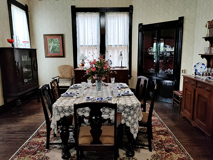 The dining room's lace tablecloth and formal place settings reveal how even everyday meals were occasions for ceremony in Casey Jones' time.