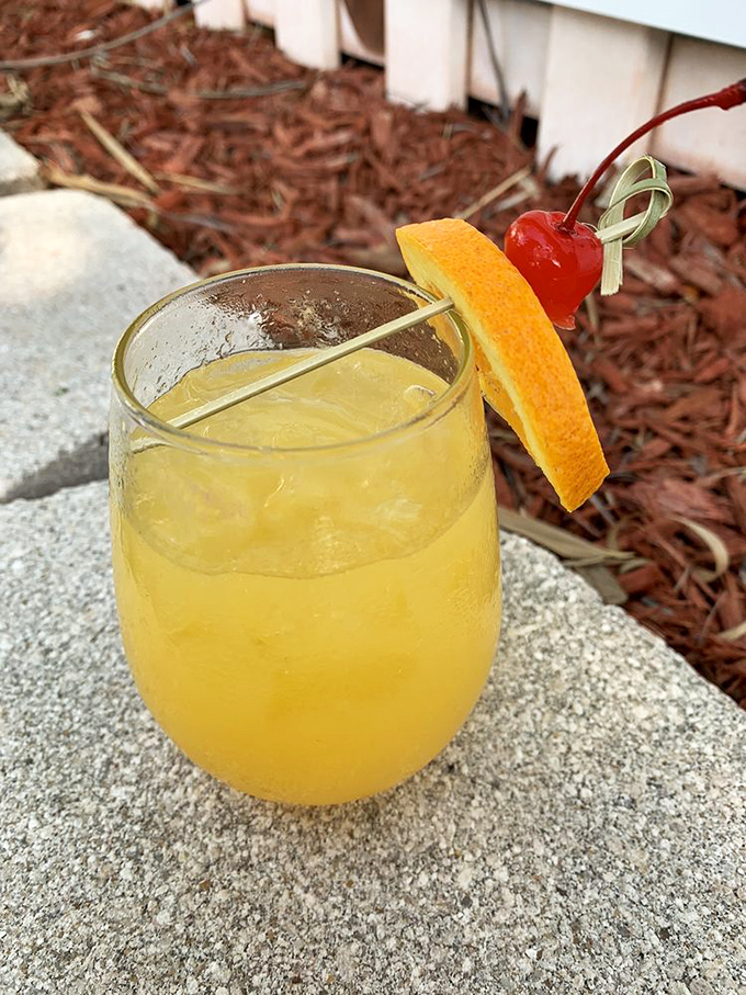 A sunshine-colored cocktail with the perfect orange garnish&mdash;because sometimes your drink deserves to dress up for the occasion too.