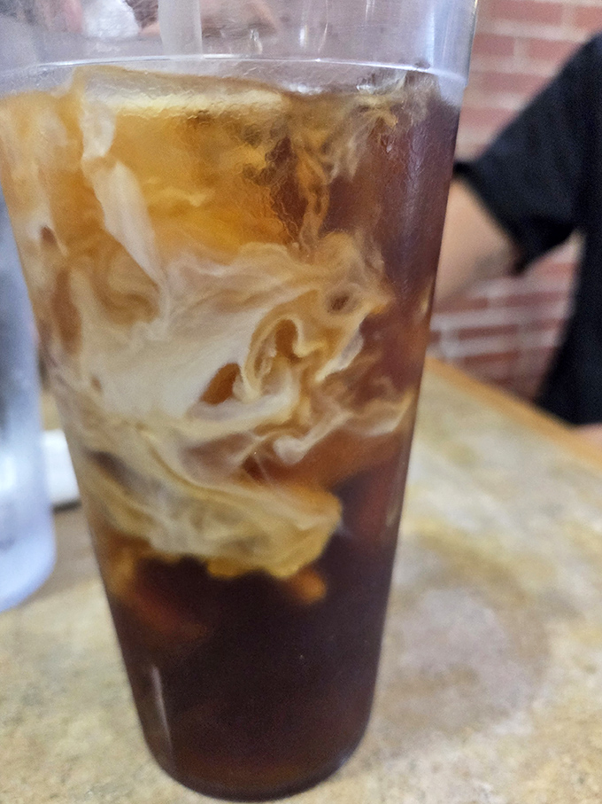 Coffee with cream swirling like a caffeinated lava lamp. The morning fuel that makes the early drive worthwhile.