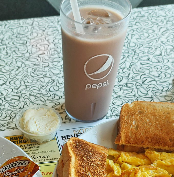 Chocolate milk in a Pepsi glass with a side of breakfast&mdash;proof that sometimes the best dining companions are simple pleasures.