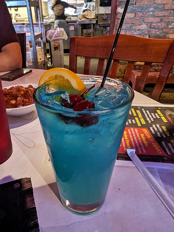 A blue cocktail that doesn't take itself too seriously, garnished with cherries and orange &ndash; because sometimes your drink should be as colorful as your vacation stories.