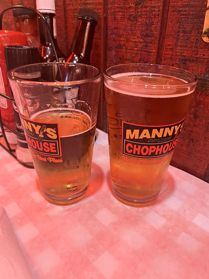 Beer glasses proudly displaying their allegiance to Manny's. In Florida's heat, these golden companions are as essential as the meal itself.
