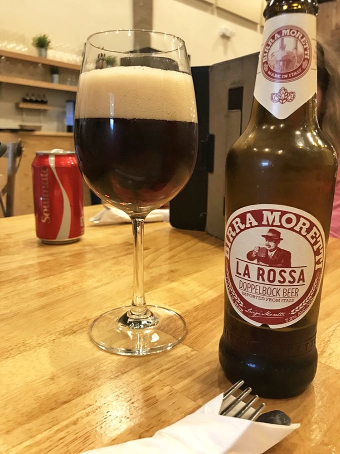 Italian beer in a wine glass? That's the kind of civilized rebellion I can get behind. Notice how even the Coca-Cola can looks impressed.