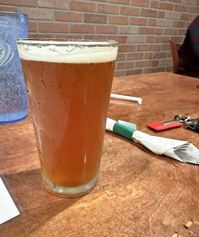 A proper pint of beer, condensation beading on the glass like it's nervous about the burger it's about to meet.