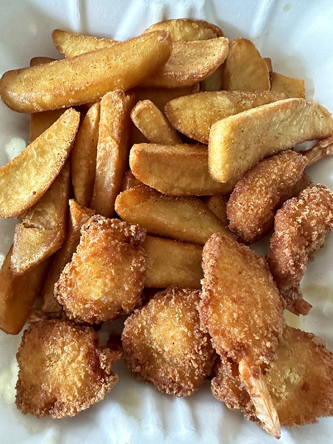 Fried shrimp with a golden crunch that echoes through the room, paired with steak fries that could convert a carb-avoider in one bite.