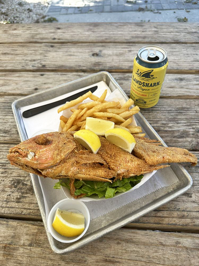 A whole fried snapper that looks ready for its close-up, complete with a citrus entourage.