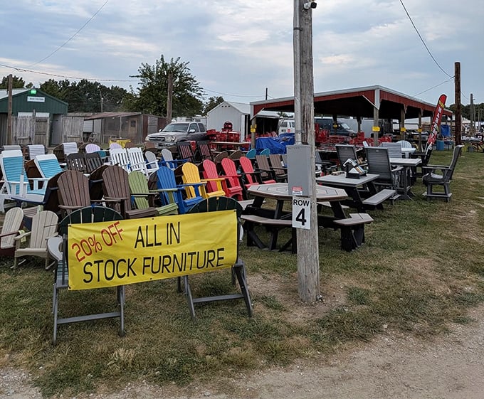 Outdoor furniture heaven where Adirondack chairs in crayon-box colors stand at attention. The "20% Off" sign is the universal flea market siren song.