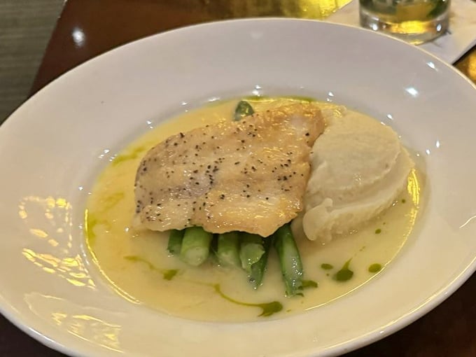 Halibut perched atop vibrant green asparagus in a buttery sauce that's practically singing. The mashed potatoes on the side are just showing off at this point.