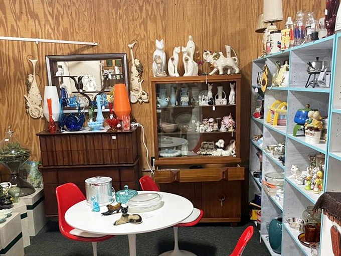 Mid-century meets whimsy in this booth where vintage cat figurines stand guard over colorful glassware and the perfect retro dining set.
