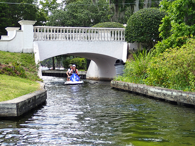 Winter Park's canal system connects its chain of lakes, where white bridges create picture-perfect moments straight out of a romance novel's cover.
