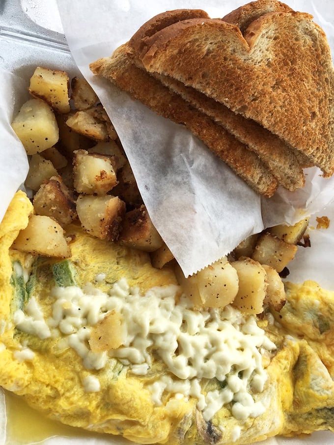 This isn't just an omelet&mdash;it's a cheese-blanketed masterpiece with home fries that deserve their own fan club.