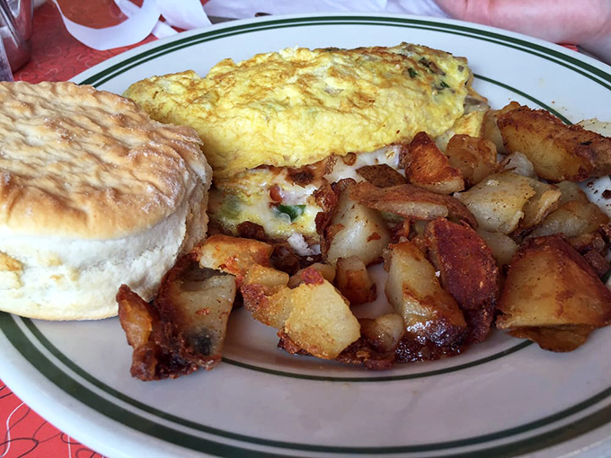 Breakfast perfection on a plate: a fluffy omelet cozying up to home fries so crispy they practically crackle when you look at them.